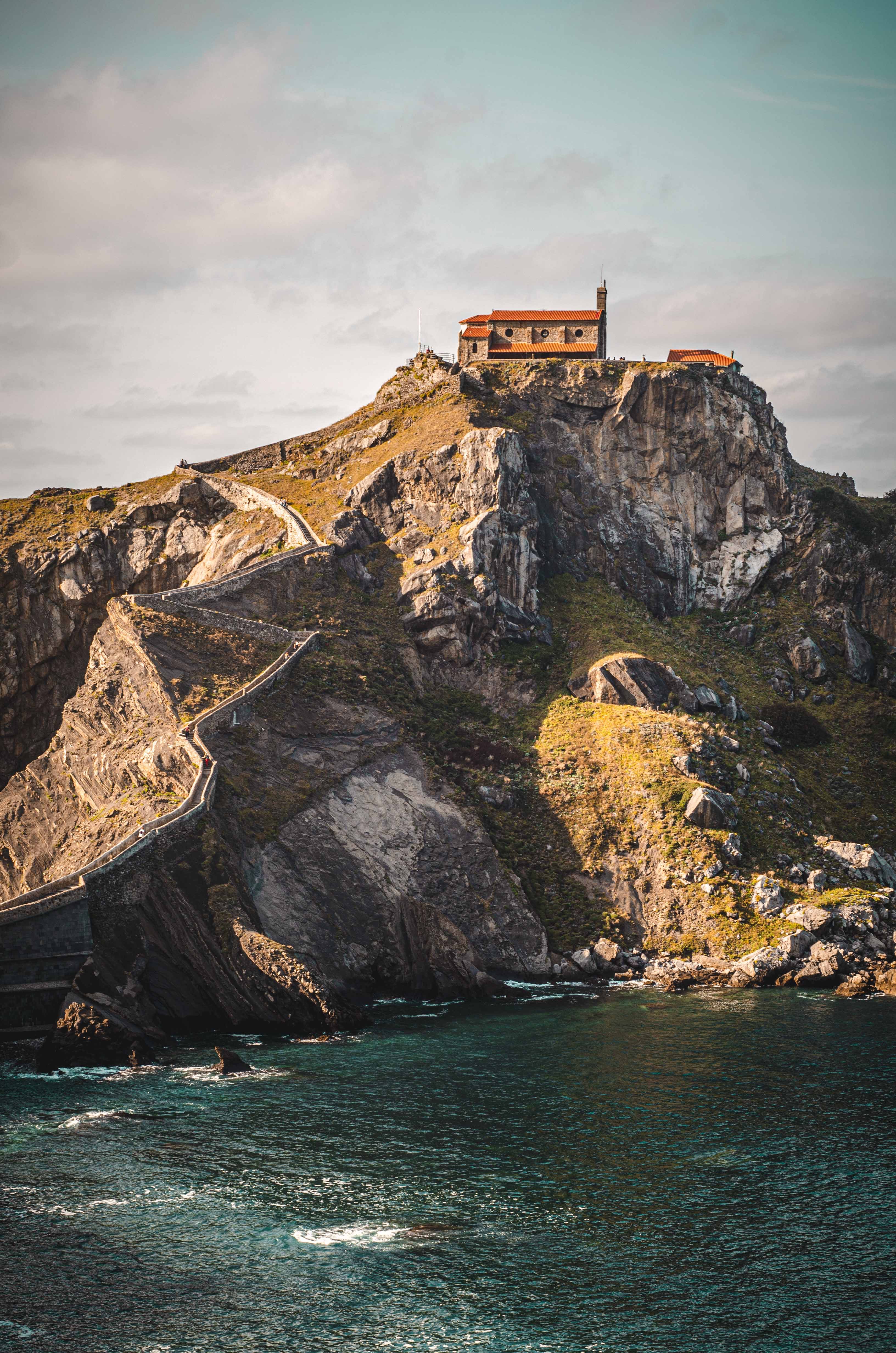 Download wallpaper 3264x4928 building, rocks, mountains, sea, road hd ...