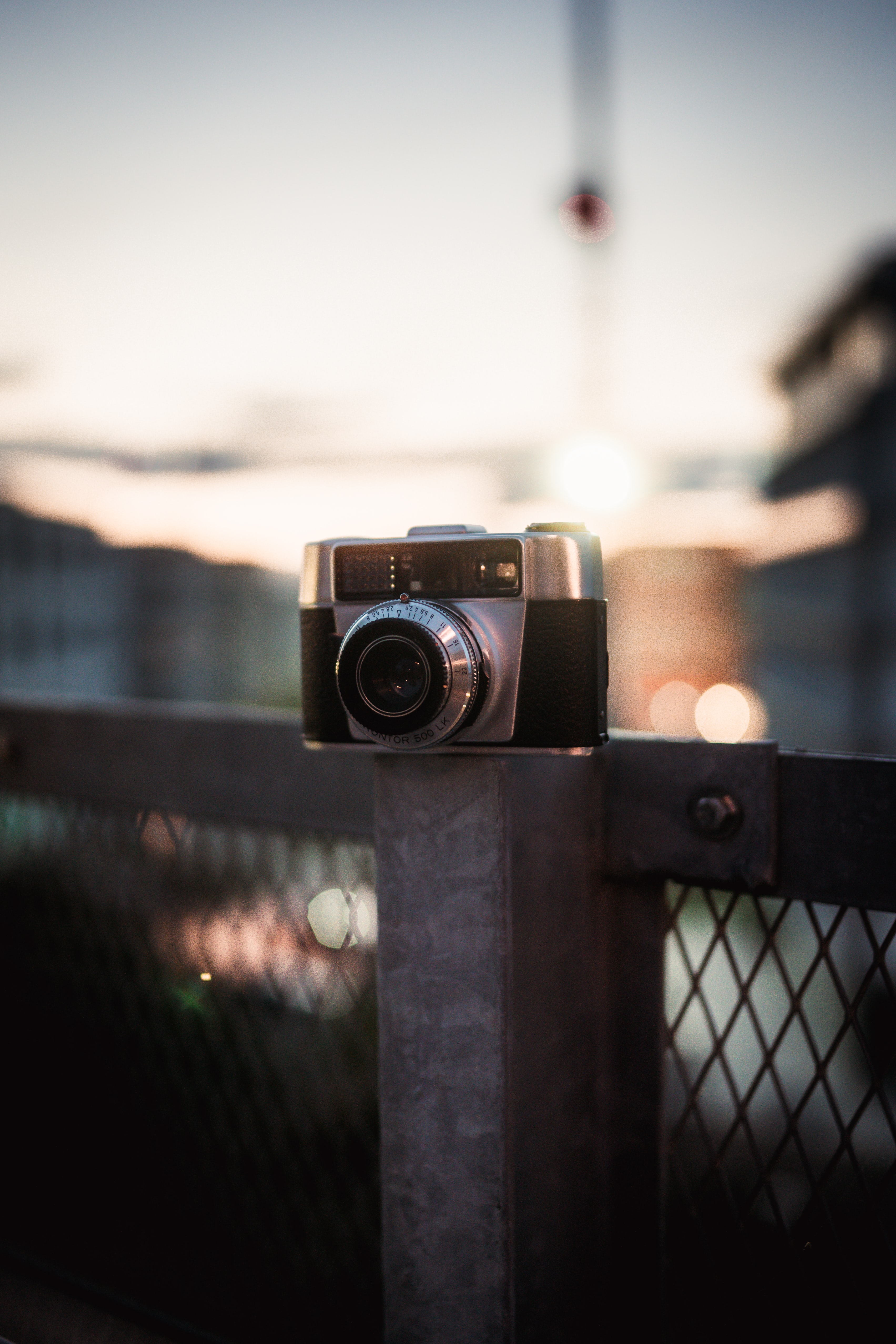 Download wallpaper 3407x5110 camera, gray, fence hd background