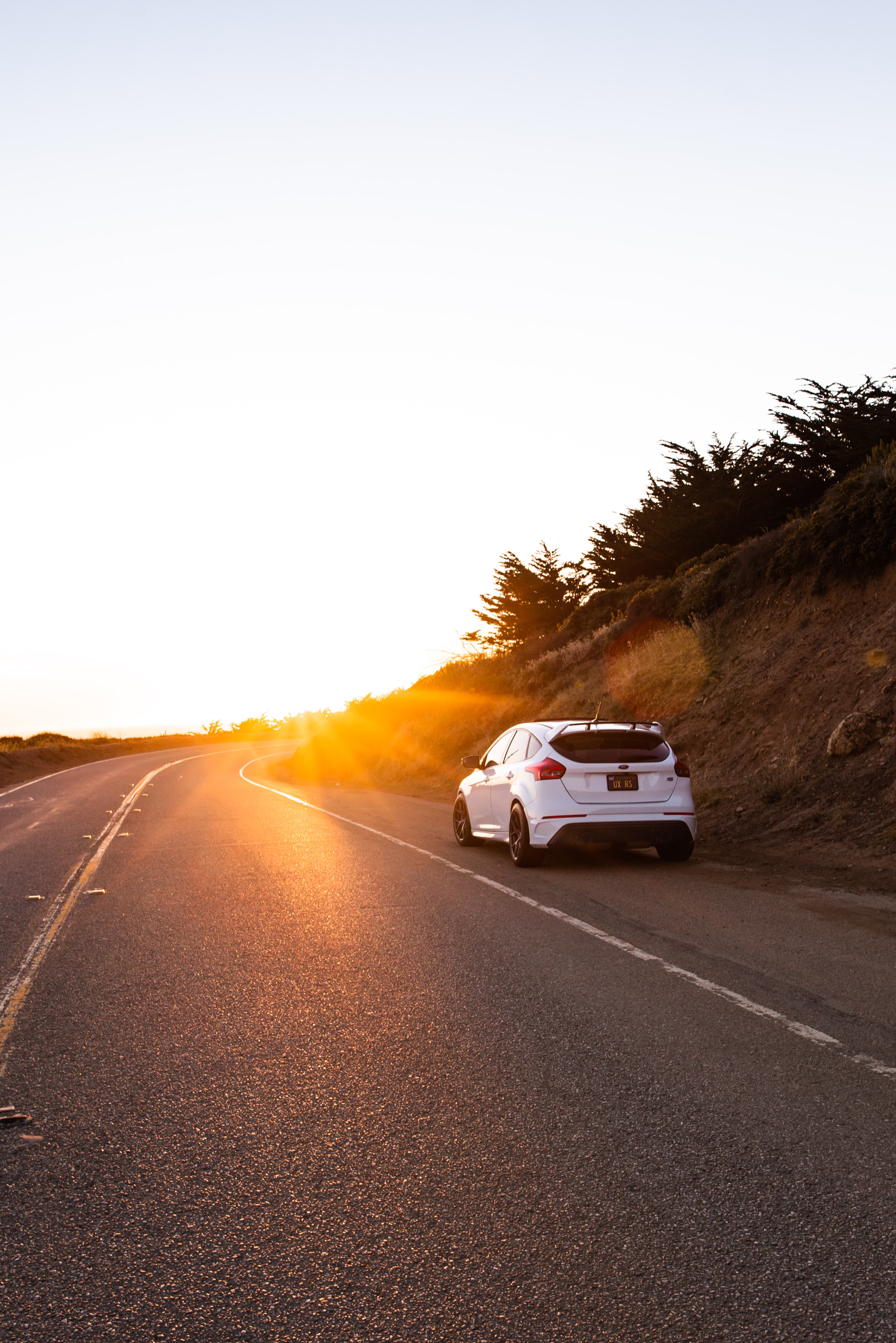 Download wallpaper 2638x3952 car, rear view, road, rays, sun hd background