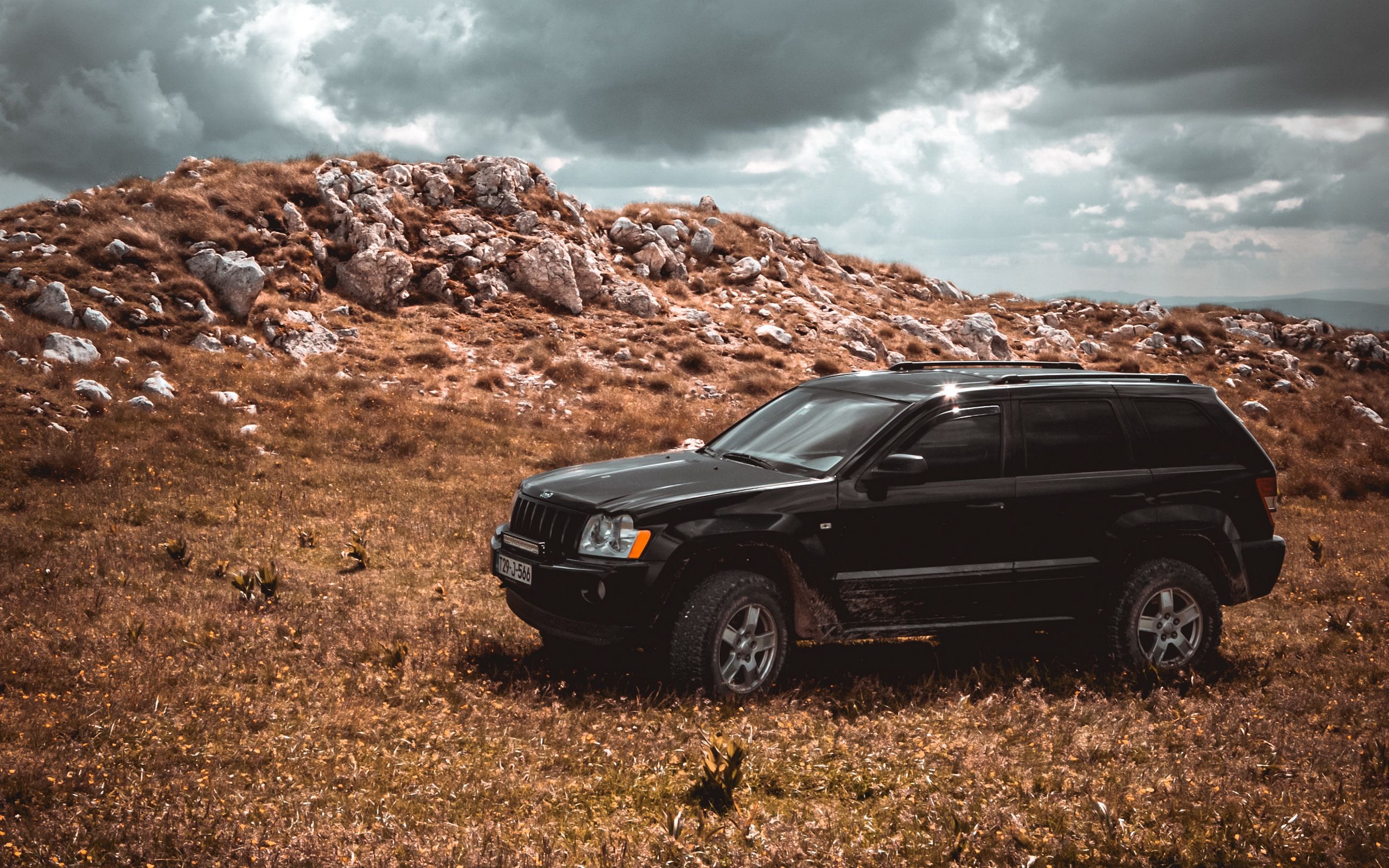 Download wallpaper 2560x1600 car, suv, side view, stones, sky ...