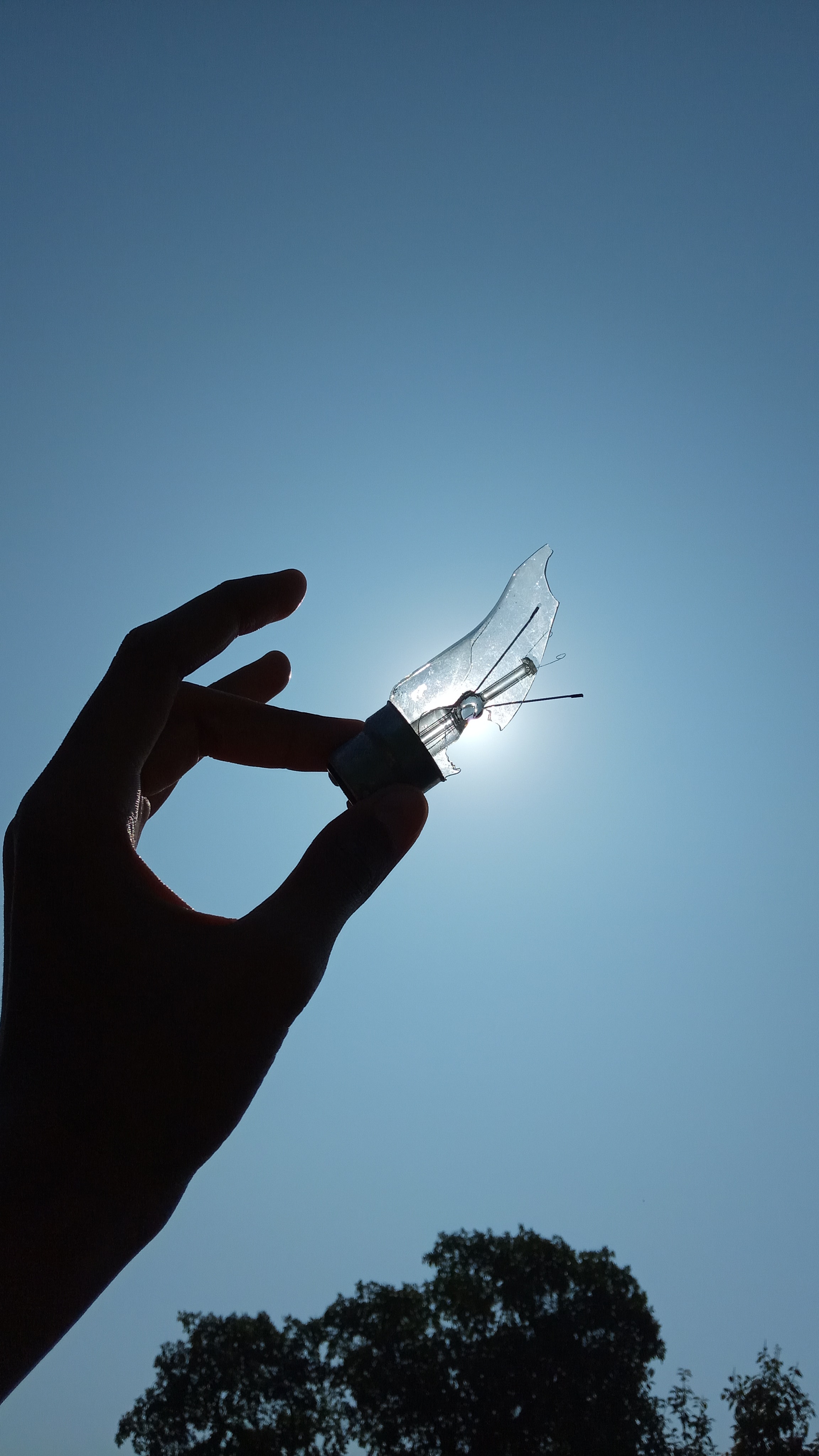 Download wallpaper 2304x4096 light bulb, hand, broken, sky hd background