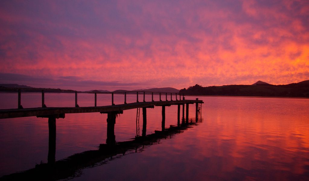 Download wallpaper 1024x600 pier, lake, hills, evening netbook, tablet ...