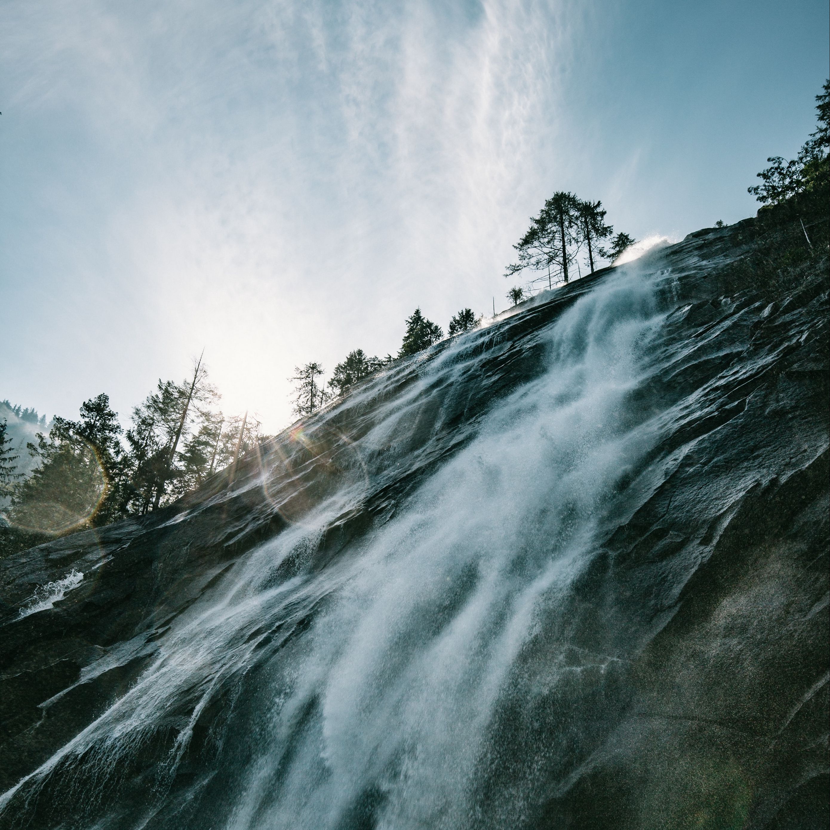 Download wallpaper 2780x2780 waterfall, cliff, trees, sunlight, flare ...